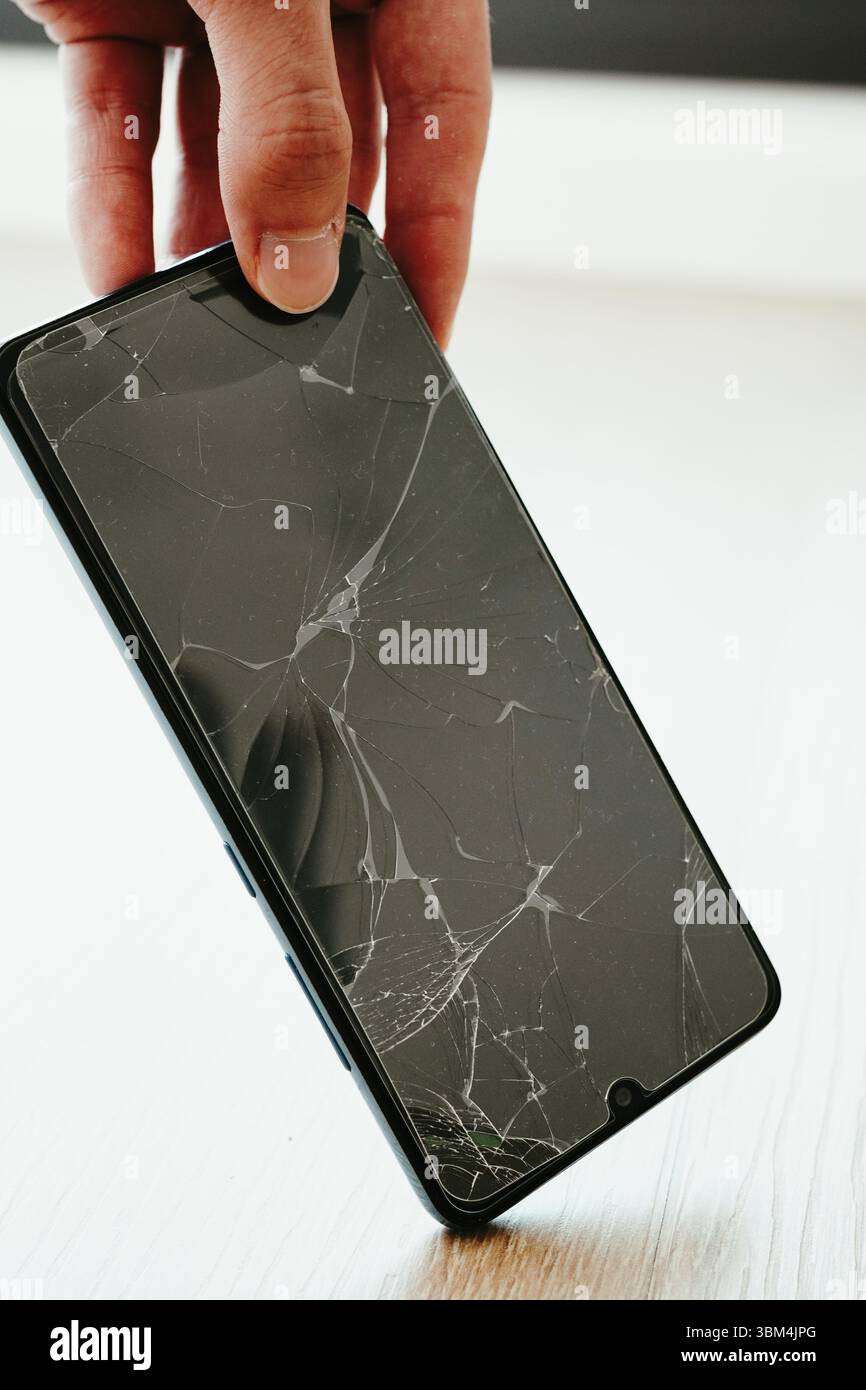 Broken cell phone screen after falling on the floor Stock Photo - Alamy