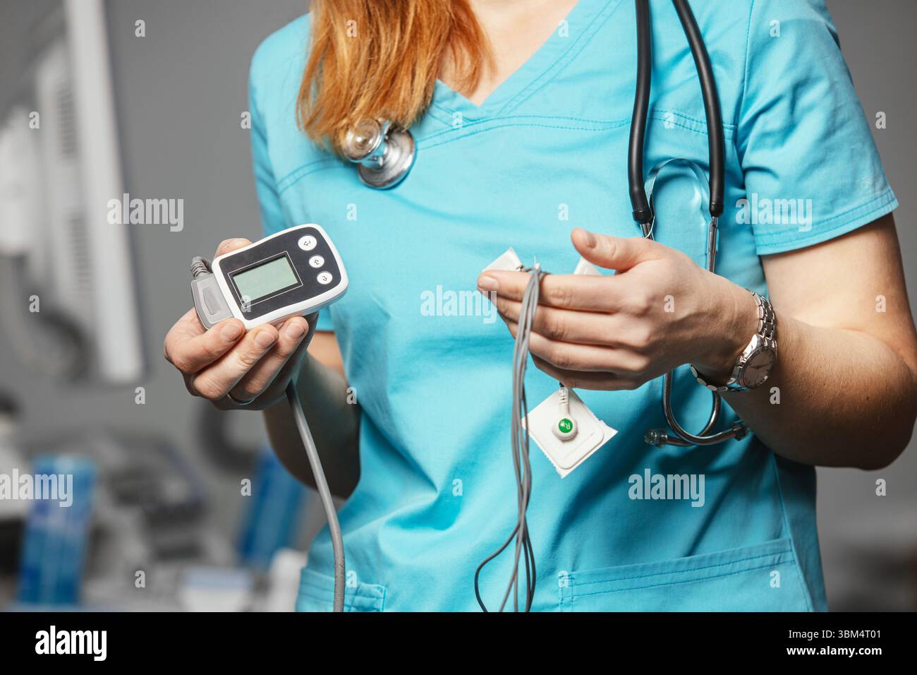 Doctor showing ECG holter monitor to patient in pediatric clinic ...