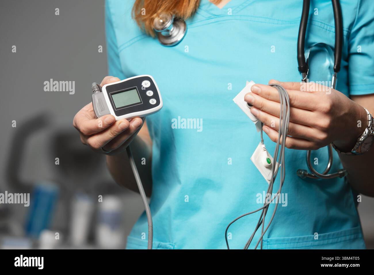 Doctor showing ECG holter monitor to patient in pediatric clinic ...