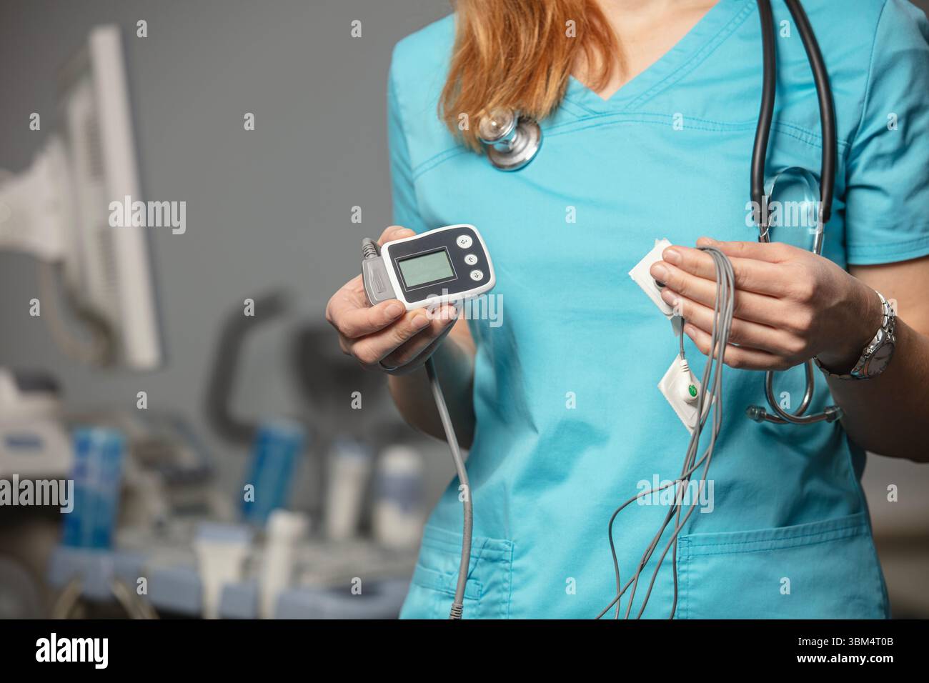 Doctor showing ECG holter monitor to patient in pediatric clinic ...