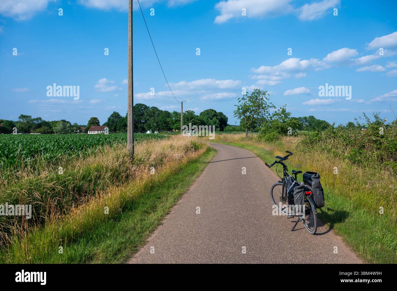 Cycling path with bike and paniers through the agriculture fields at ...