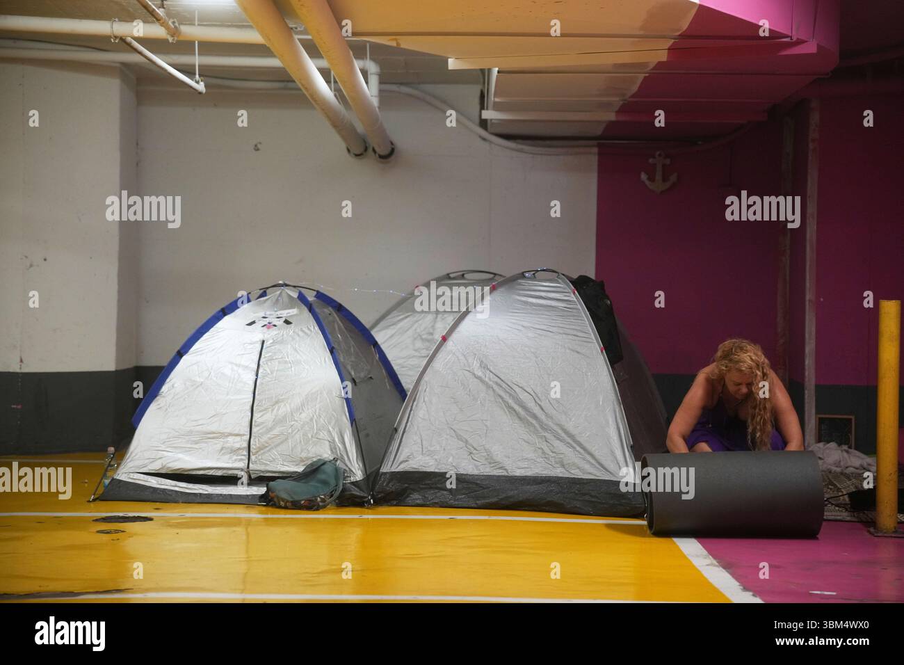 A woman folds tents at an underground shelter she stayed in during ...