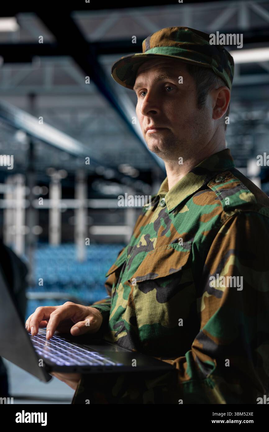 Military officer managing logistics operations using laptop in server ...