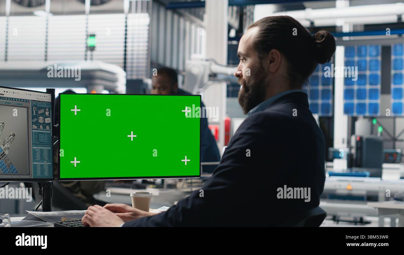 Young business specialist uses computer with green screen and ...