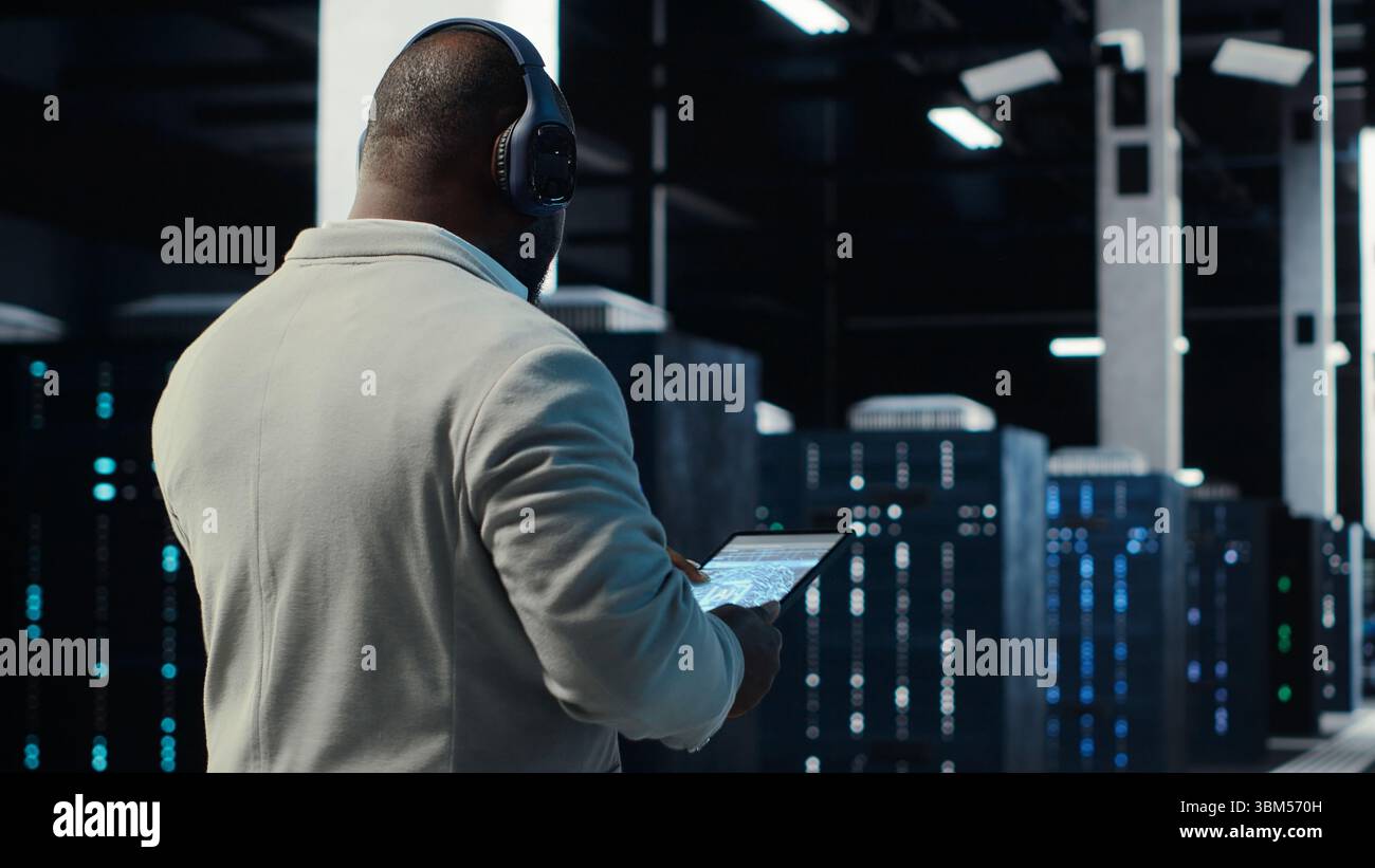 Admin walking in data center, listening music while doing inspection on infrastructure tech. IT ...
