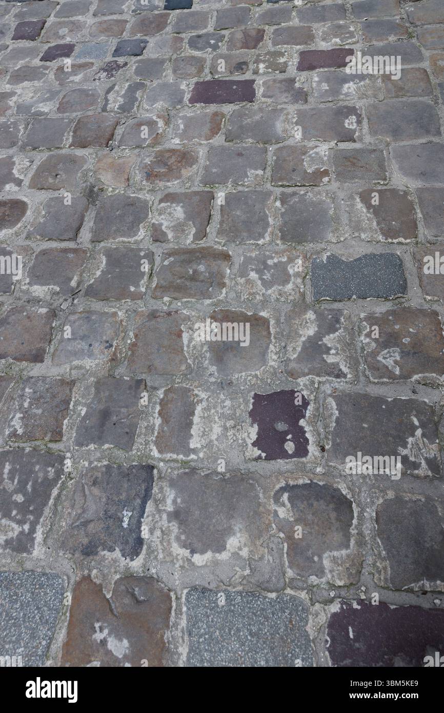 An intricate view of a cobblestone street featuring a mix of textures ...