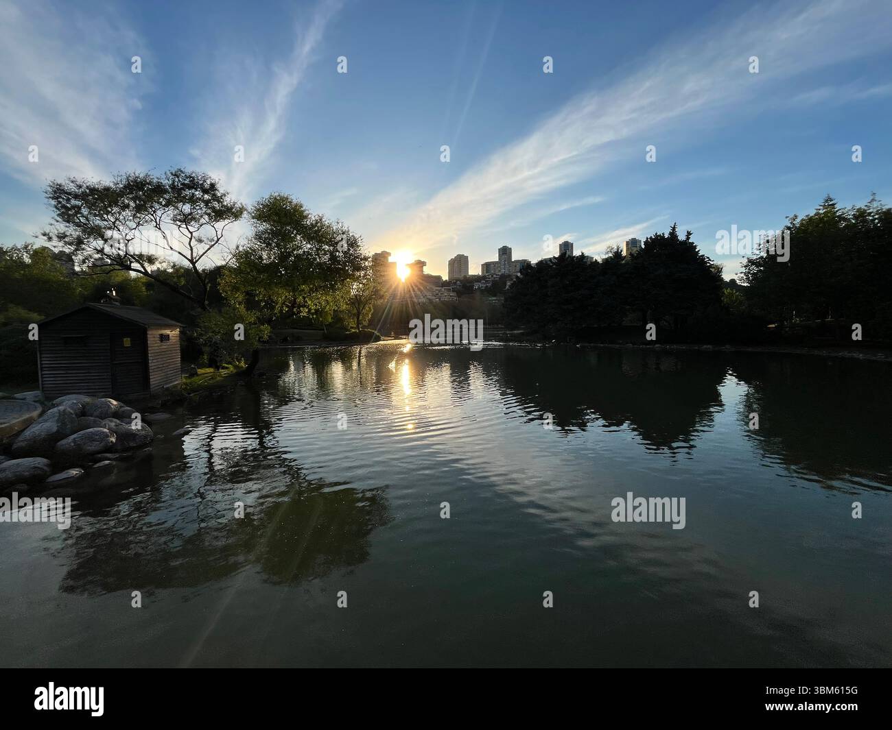 Lake park view and behind modern buildings silhouette at sunset in ...