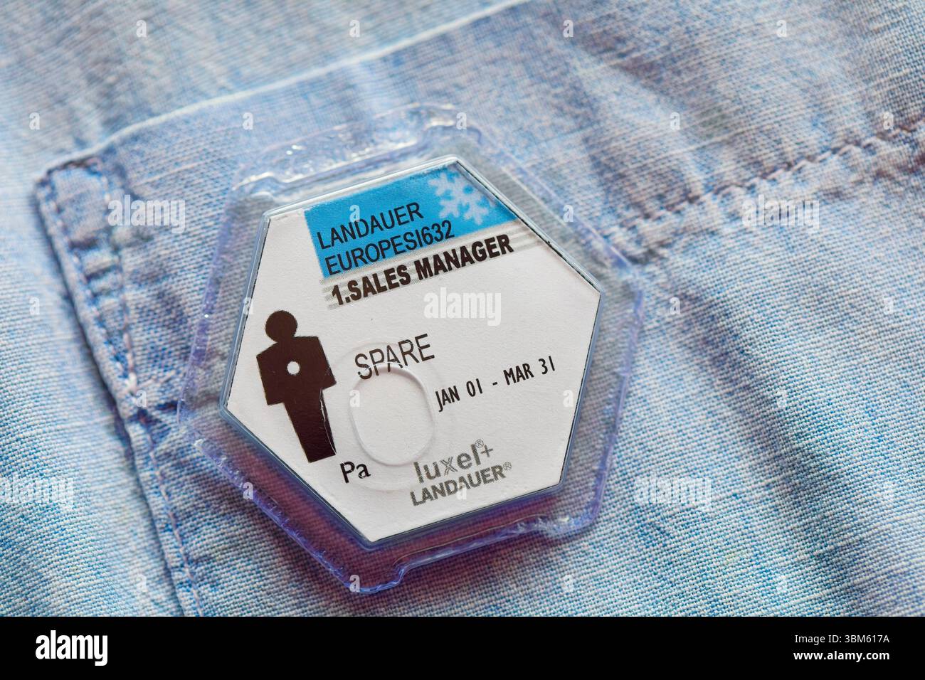 Dosimeter badge. This badge is a dosimeter worn by persons to detect X ...