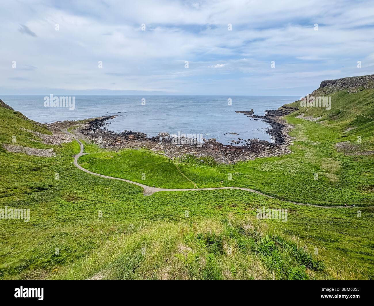 Causeway coast landscape view showing green hills, bay with rocky shore ...