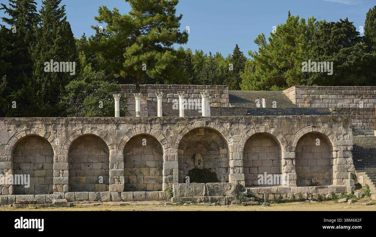 Wide angle view of ancient ruins and stone arches with dense forest in ...