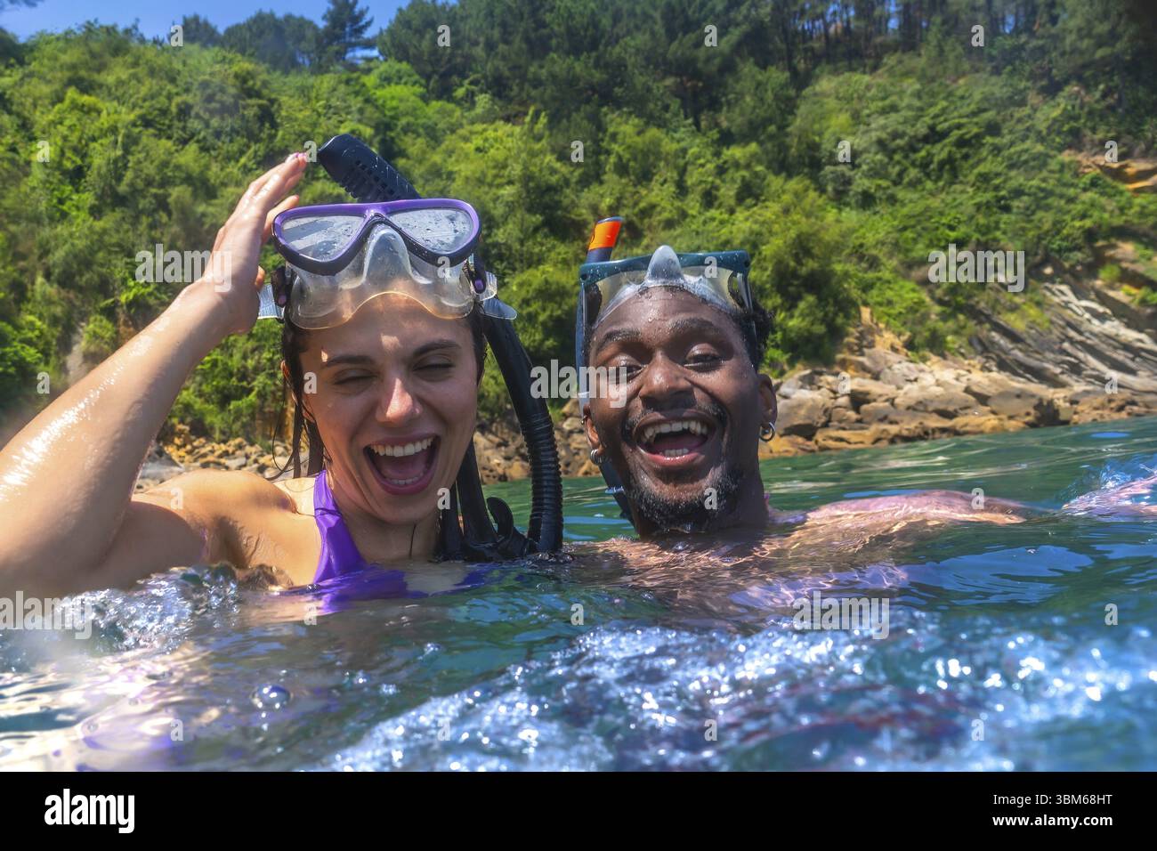 Interracial couple enjoying a fun snorkeling adventure in the vibrant ...