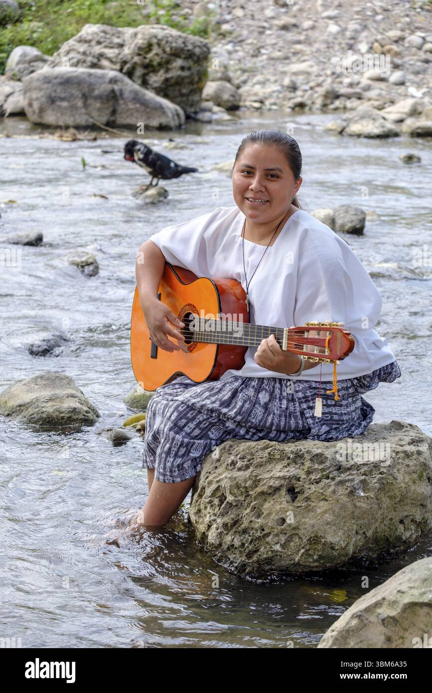 Nun playing guitar in the river, La Tana, Zona Reina, Quiche, Guatemala ...