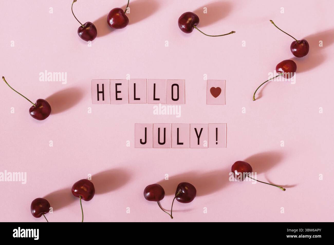 Hello July text and cherry berry scattering on pink background. Hello ...