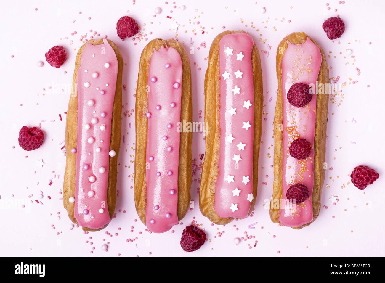 Creative layout made of eclairs with pink glaze on white background. Food concept Stock Photo ...