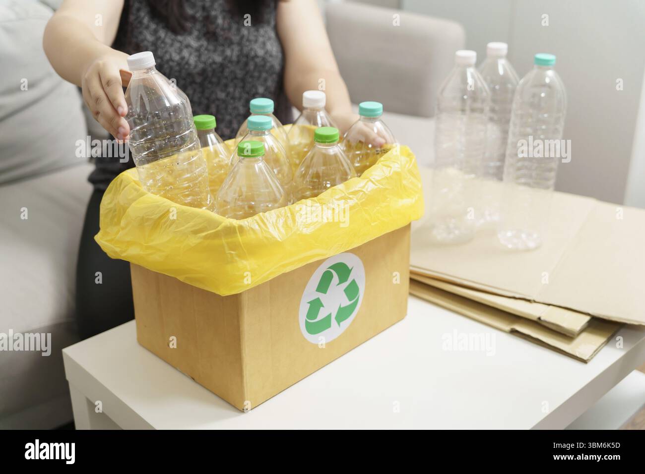 Home recycle eco green zero concept Woman throwing empty plastic bottle in recycling bin with ...