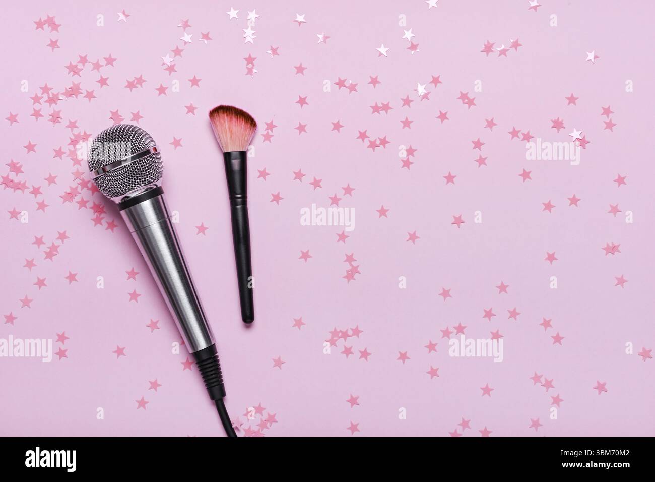 Microphone, confetti and brush on pink background. ASMR recording ...