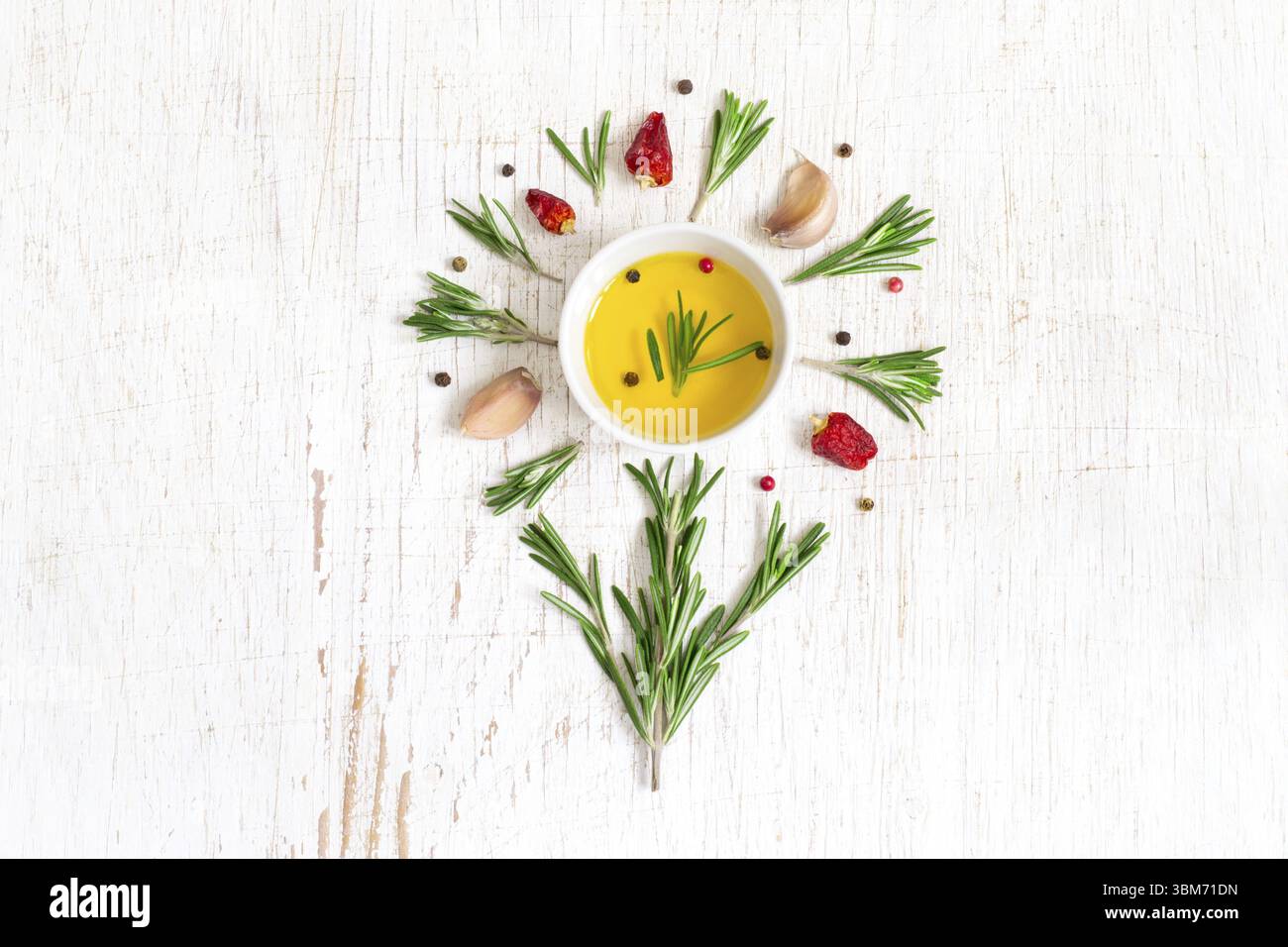 Olive oil, rosemary and spices. Herbs and spices are laid out in the ...