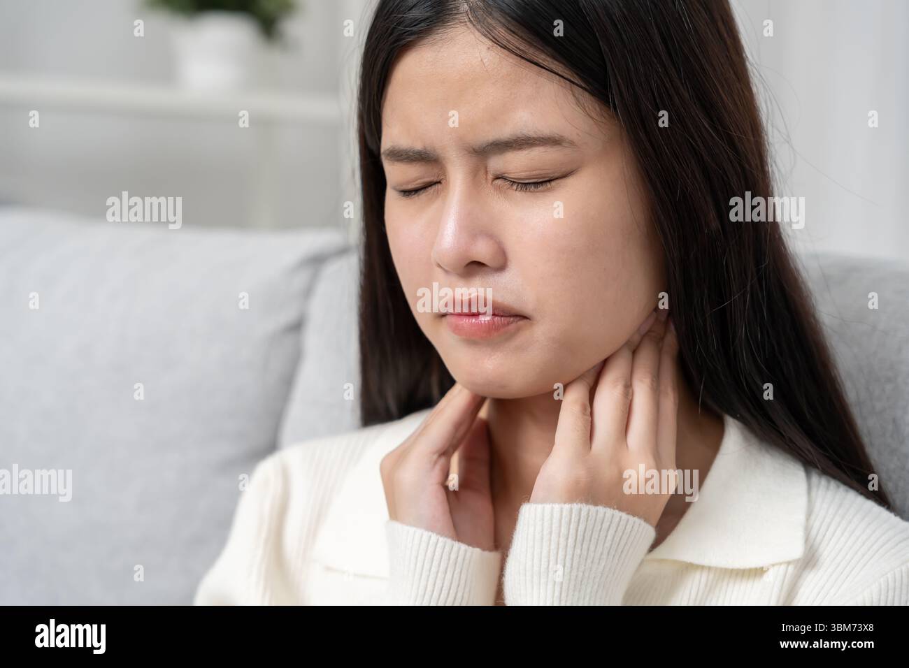Asian woman put on neck due to a sore throat. female tonsillitis causes ...