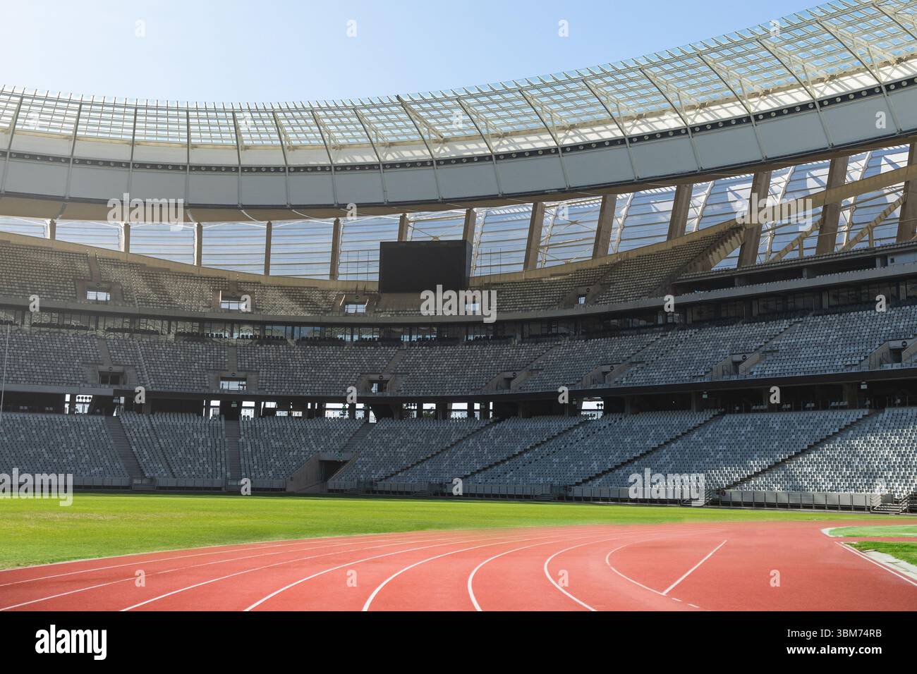 Modern athletics stadium is featuring red track, green infield and gray ...