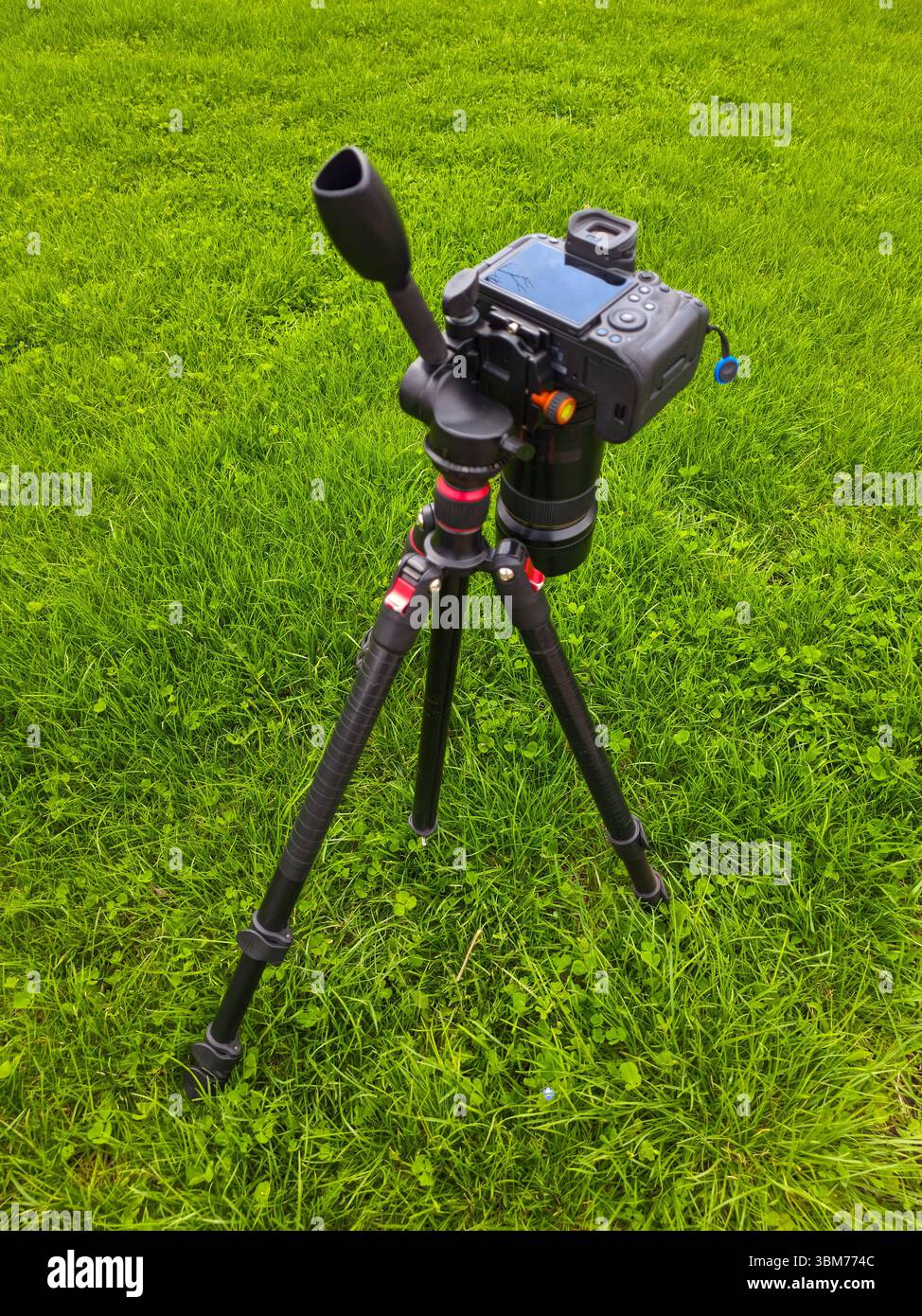 Camera mounted on tripod shooting lawn during daytime Stock Photo - Alamy