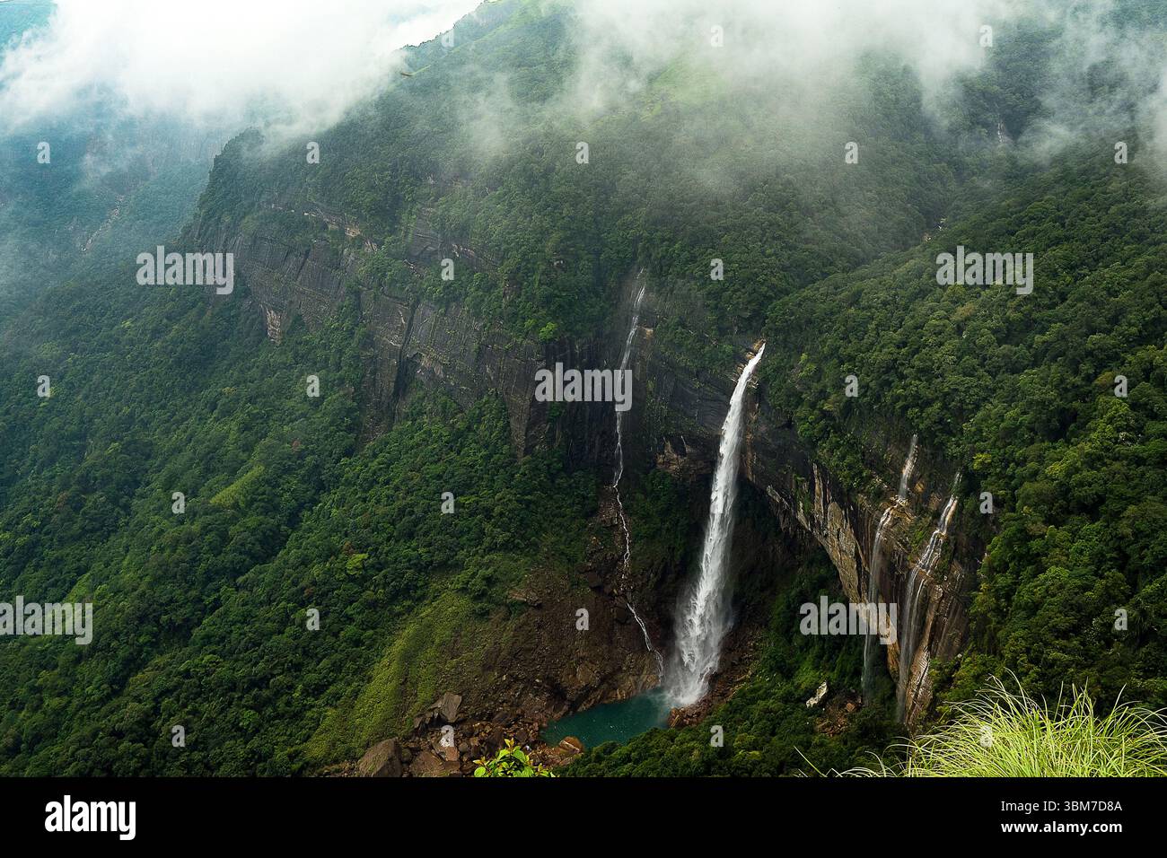 A dramatic and misty view of NohKaLikai Waterfalls, located in ...