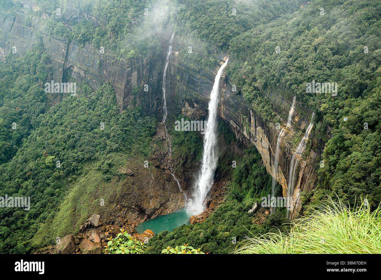 A dramatic and misty view of NohKaLikai Waterfalls, located in ...