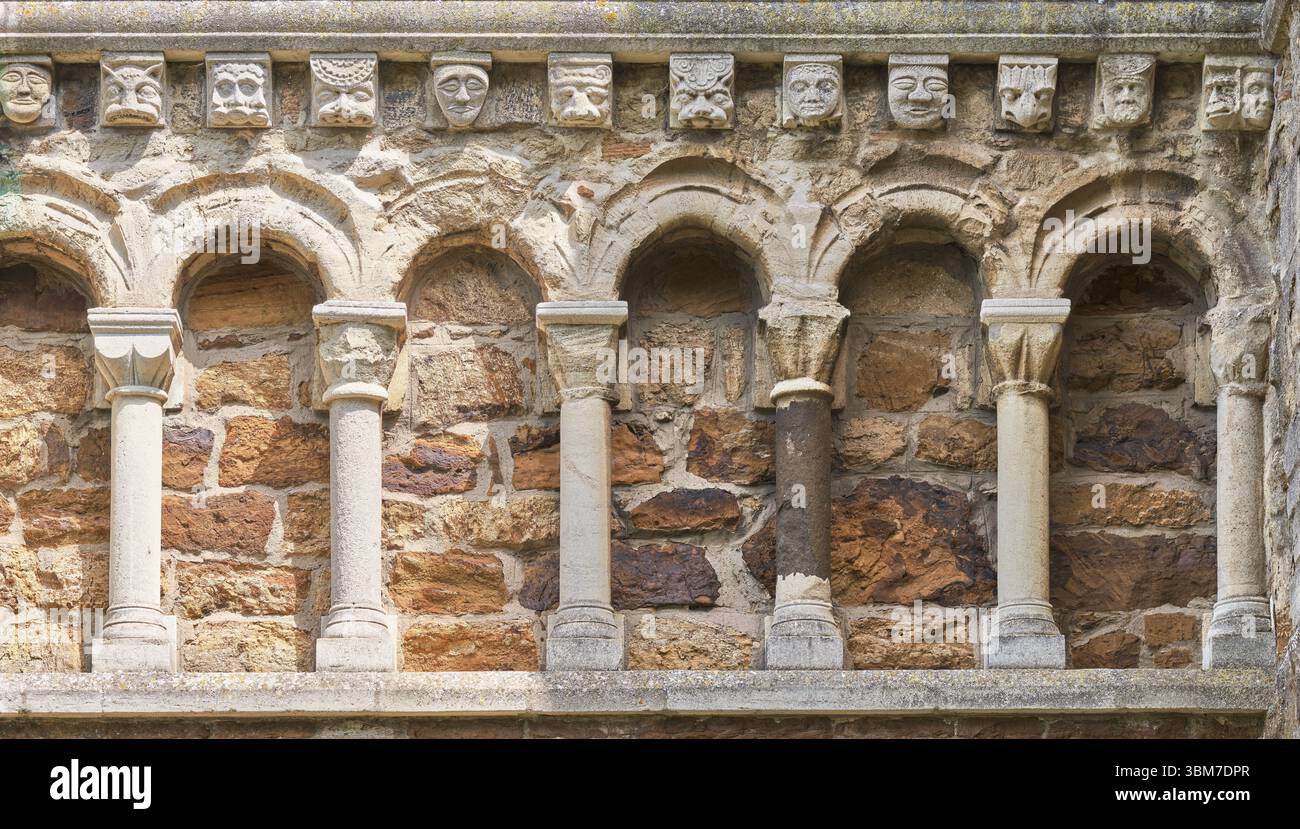 Decorative round arches and heads on an outside wall at St Peter's ...