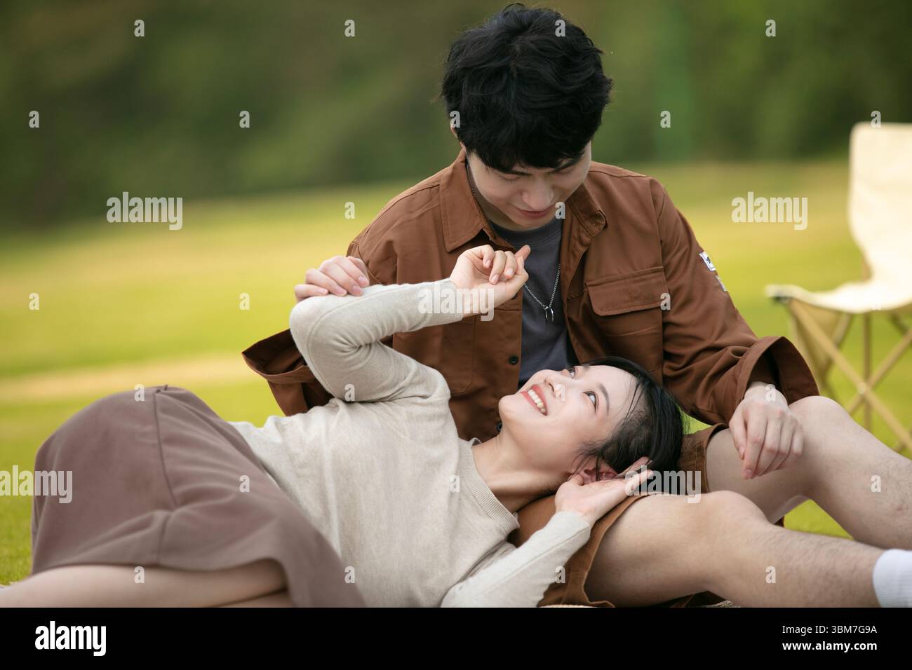 A young woman resting in the young man's arms Stock Photo - Alamy
