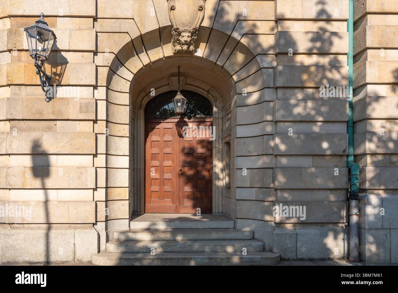 An old stone entrance portal with a massive wooden door and a classic ...