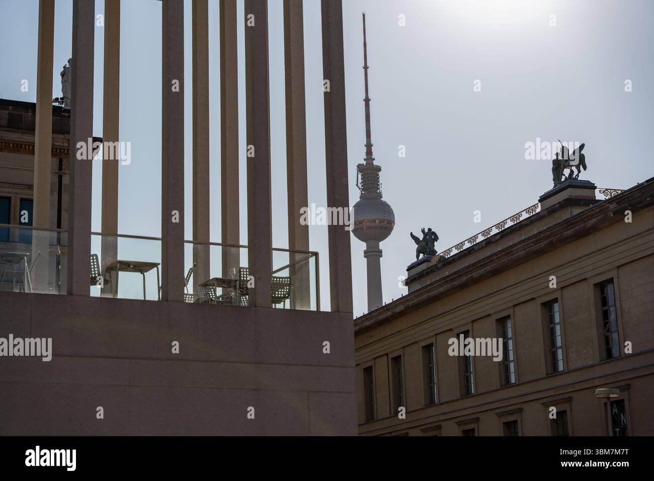 The Berlin TV tower is visible through modern columns, next to it are ...