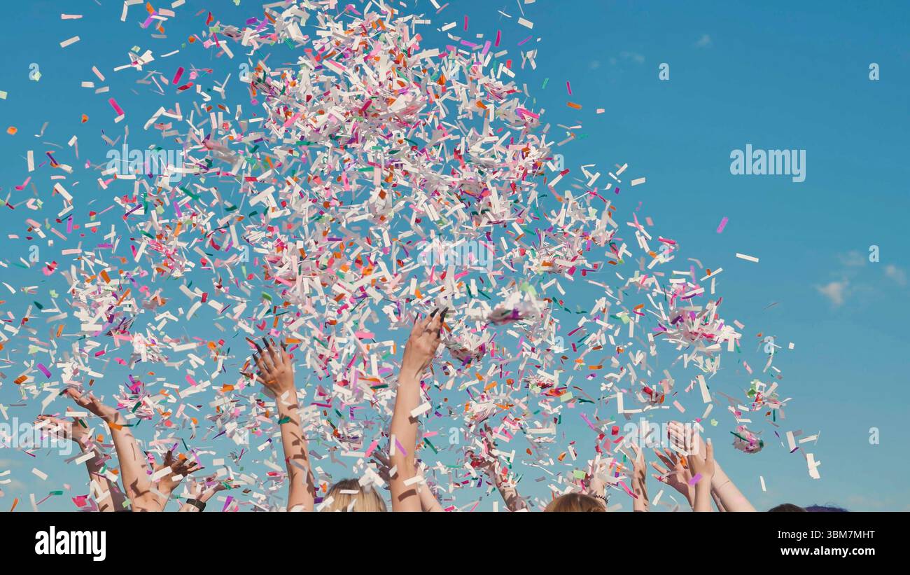 Group of high school students throwing colorful confetti in the air ...