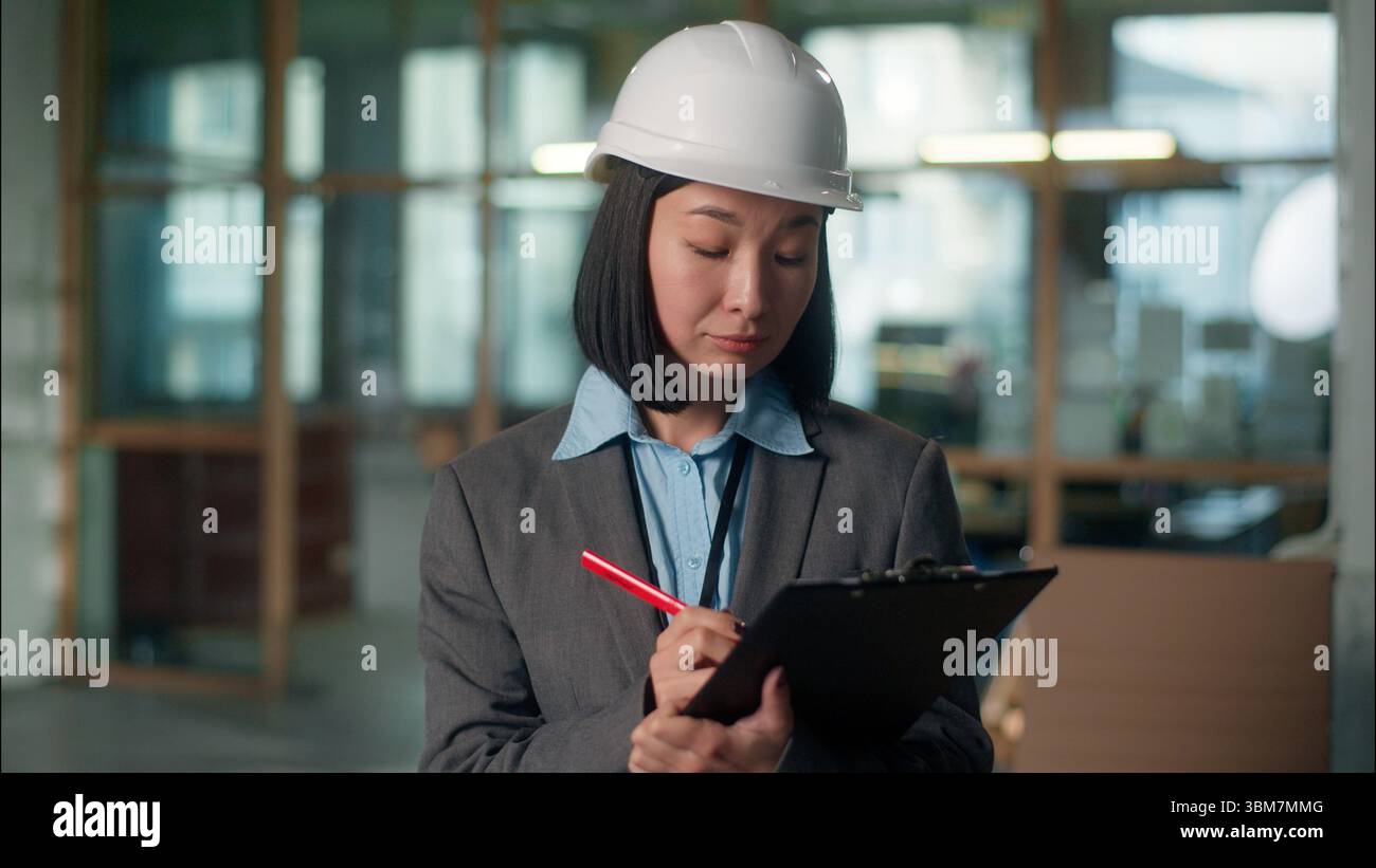 Woman architect checking building plan Asian girl builder writing sign ...