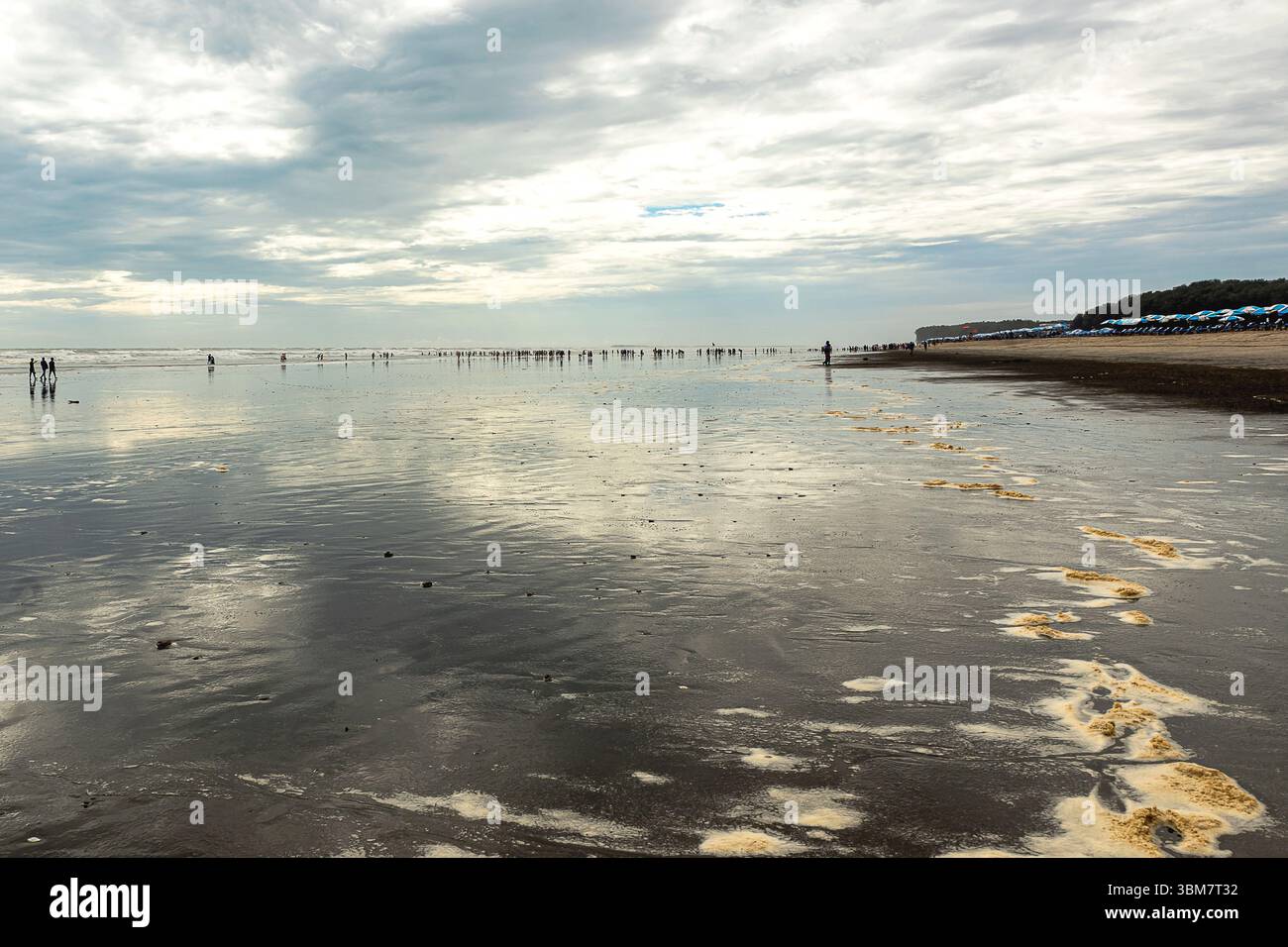 A tranquil beach scene captures gentle waves receding at low tide ...
