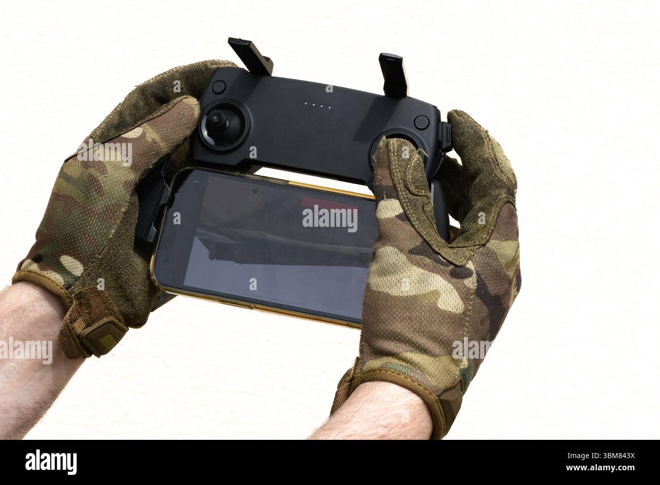 Operator in military colored gloves holding remote control panel ...