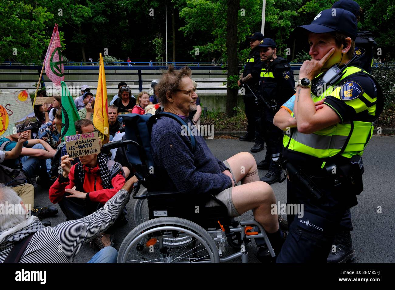 Demonstrators protest against the NATO summit as police block the road ...