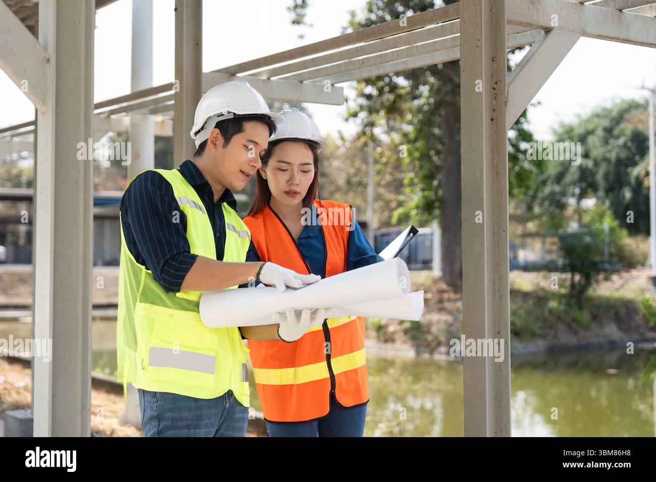 Construction Teamwork. Engineers analyzing plans together outdoors ...