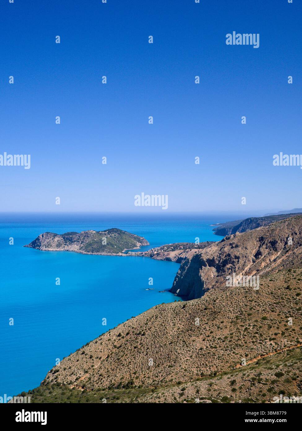 Dry cliffs and bright turquoise waters along Assos Bay on the island of ...
