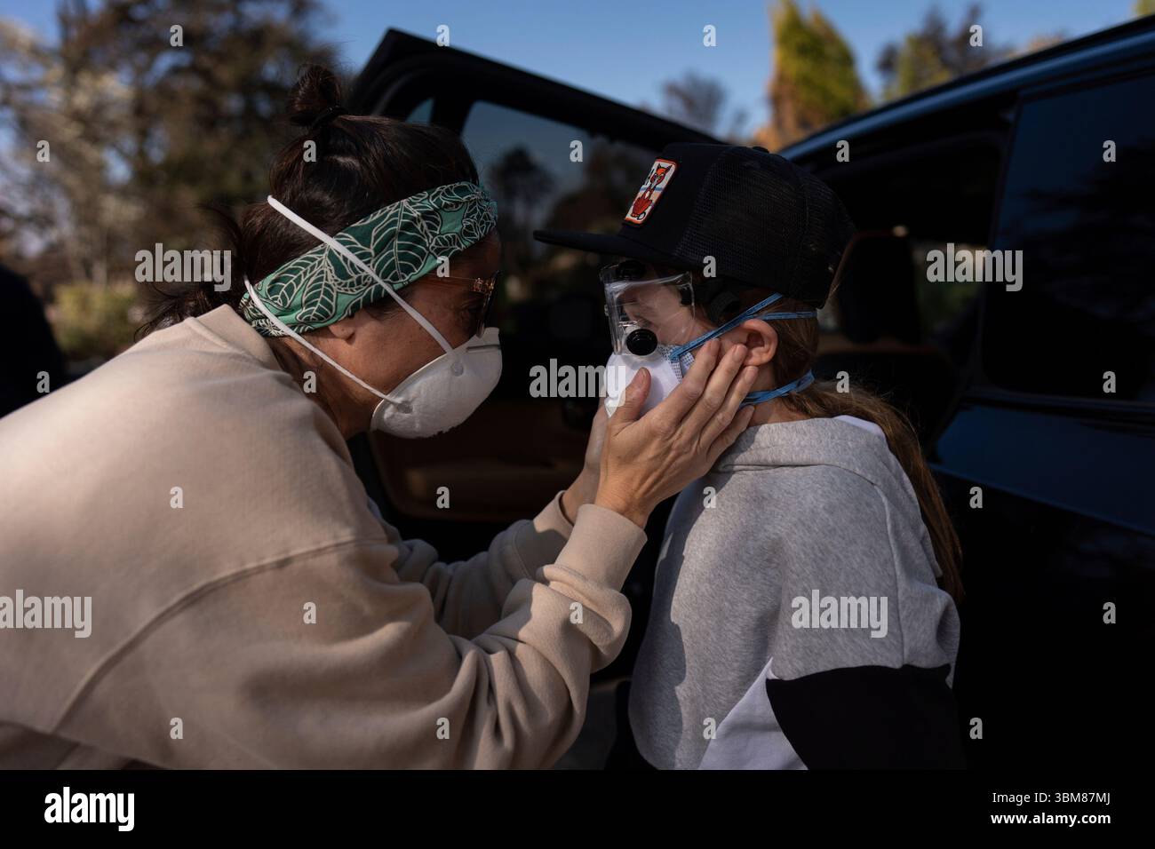 FILE - Eaton Fire evacuee Alyson Granaderos, left, sobs while trying to ...