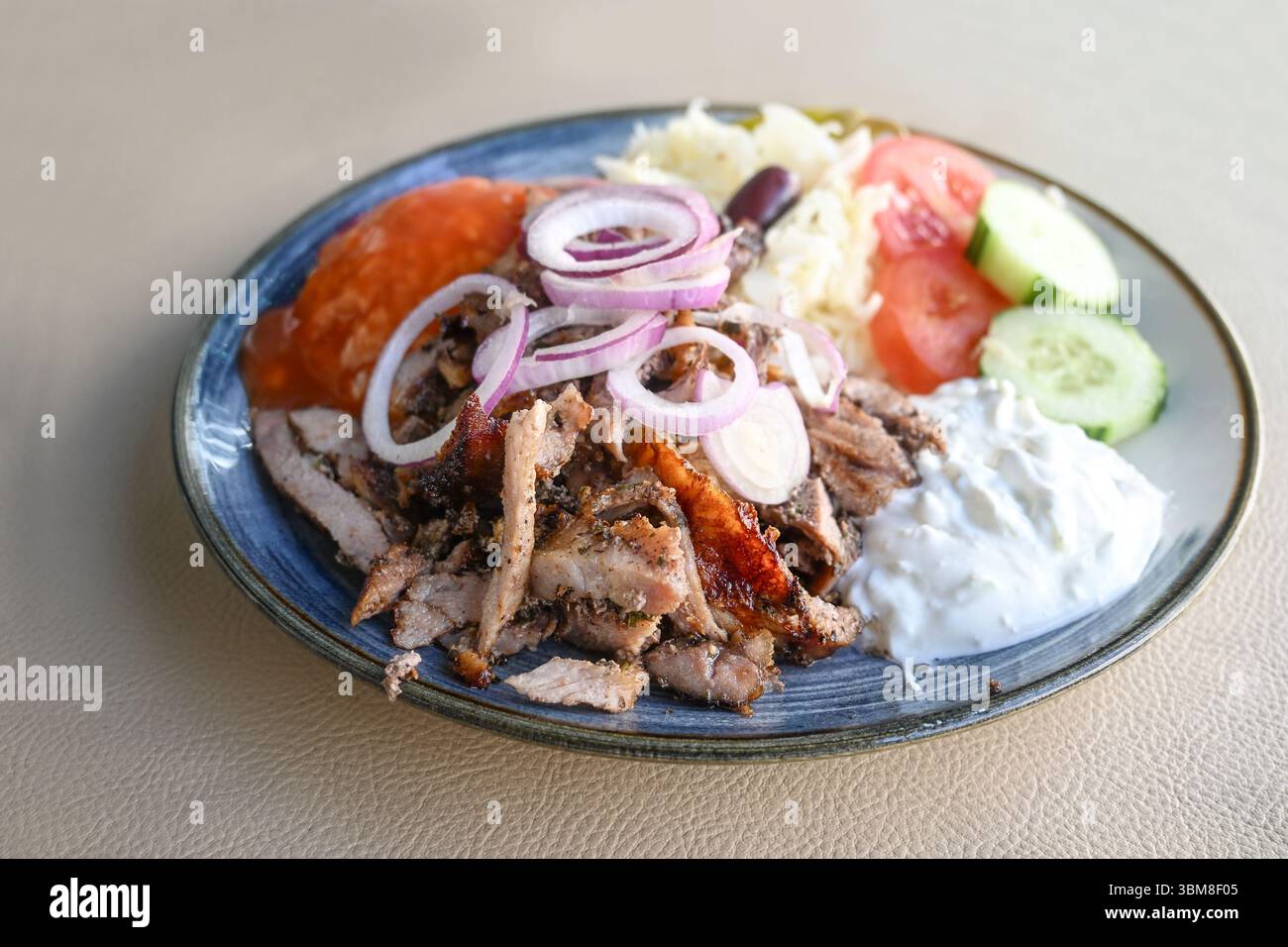 Gyros served with onions, coleslaw, rice with sauce and tzatziki on a ...