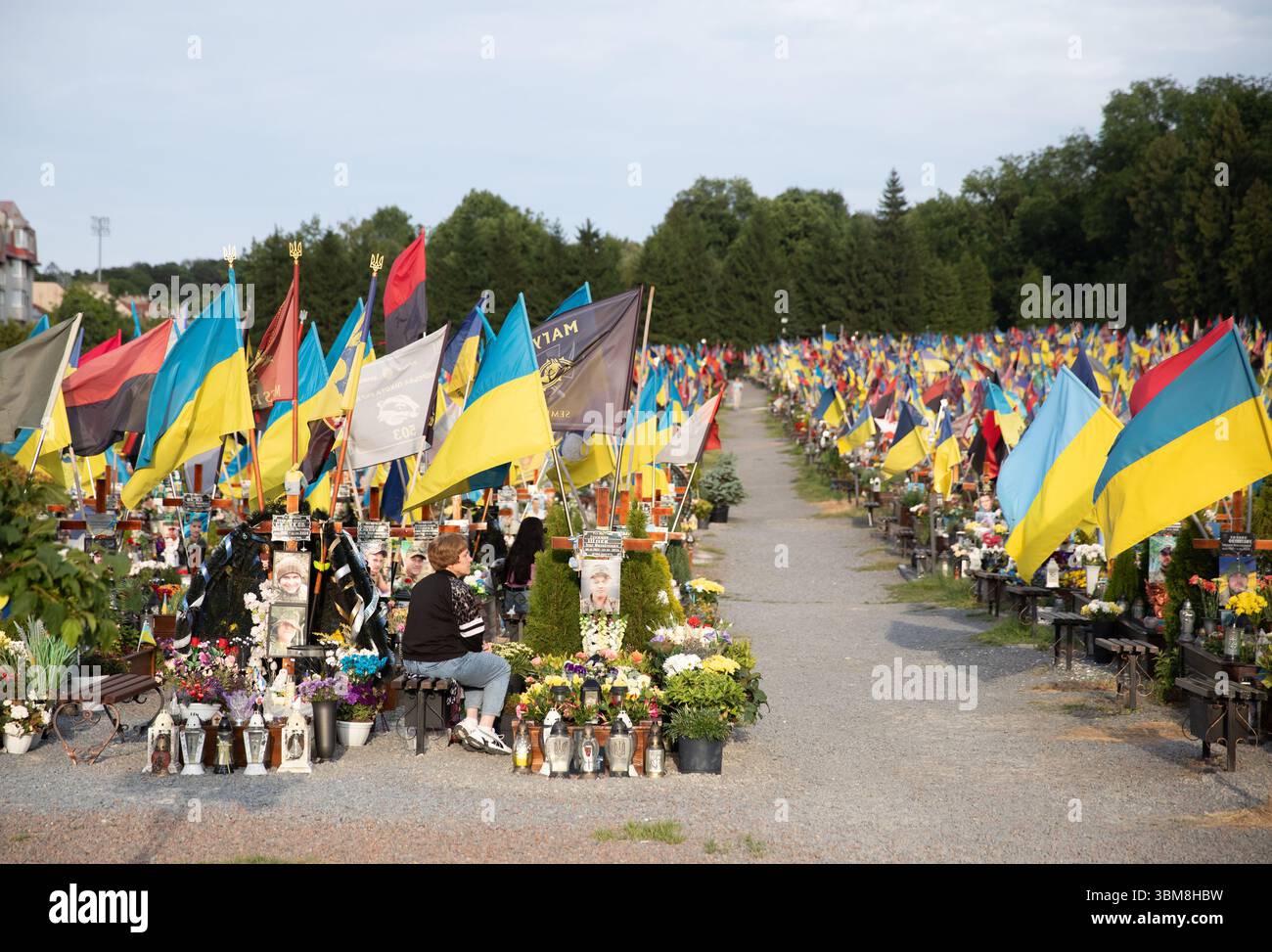 Ukrainian flags are seen alongside tributes and flowers honoring fallen ...