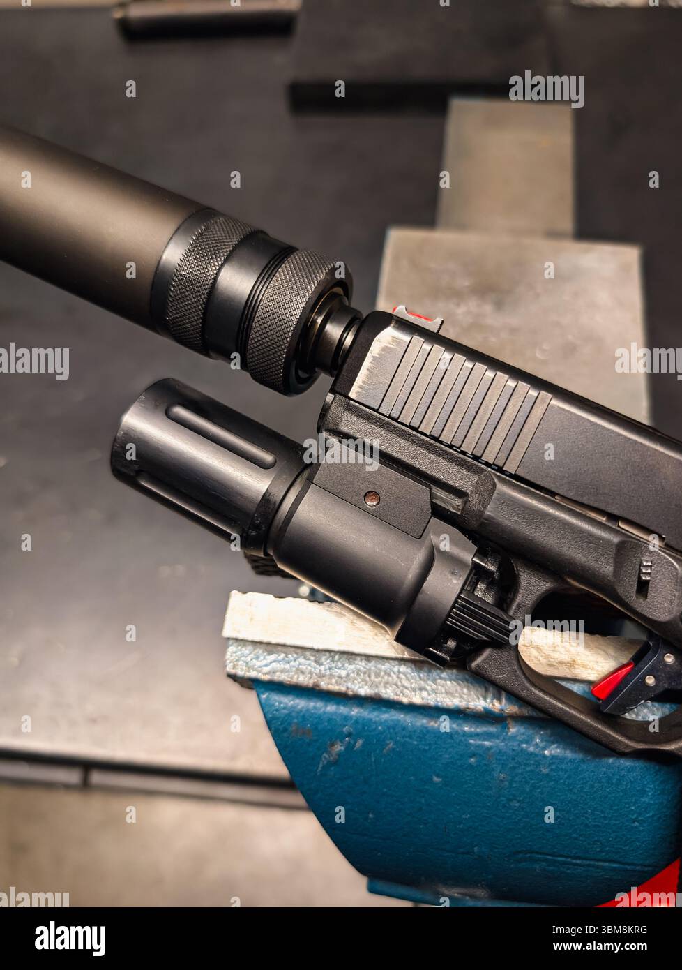 Vertical photo of a modern pistol with a suppressor and a tactical ...