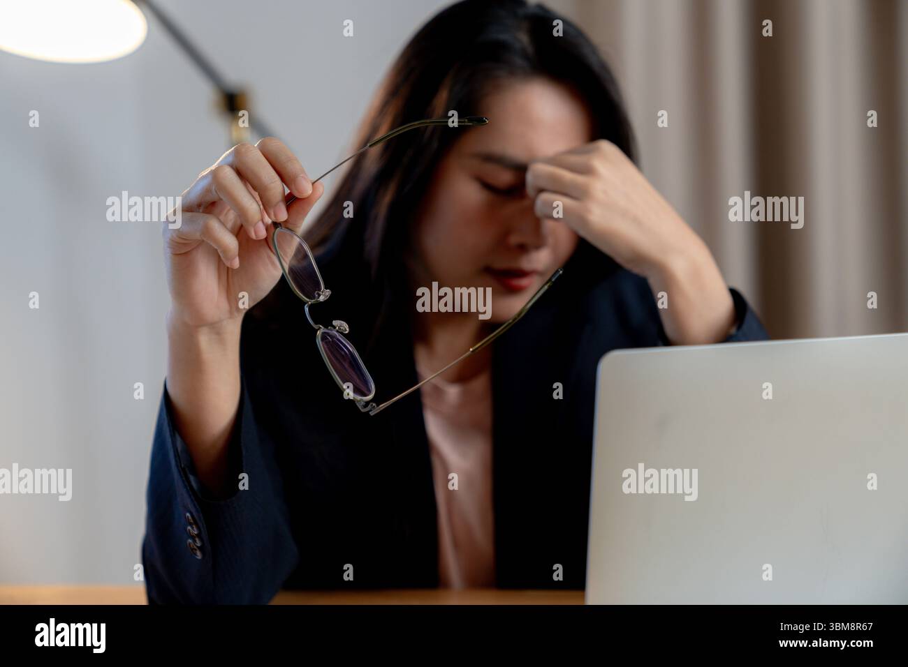 Exhausted female office worker feeling eye fatigue after working late ...