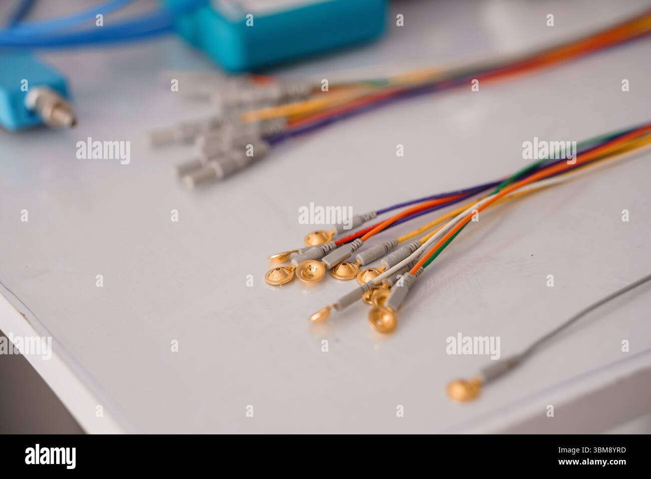 A close-up shot displays a grouping of gold EEG electrodes with bright ...