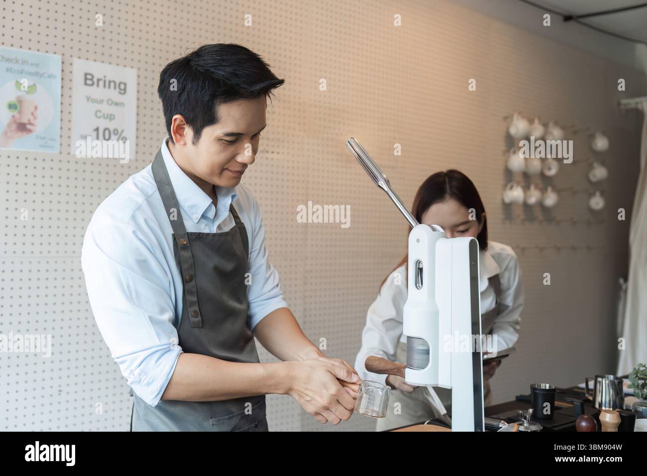 Coffee Preparation and Teamwork. A barista working behind the counter ...