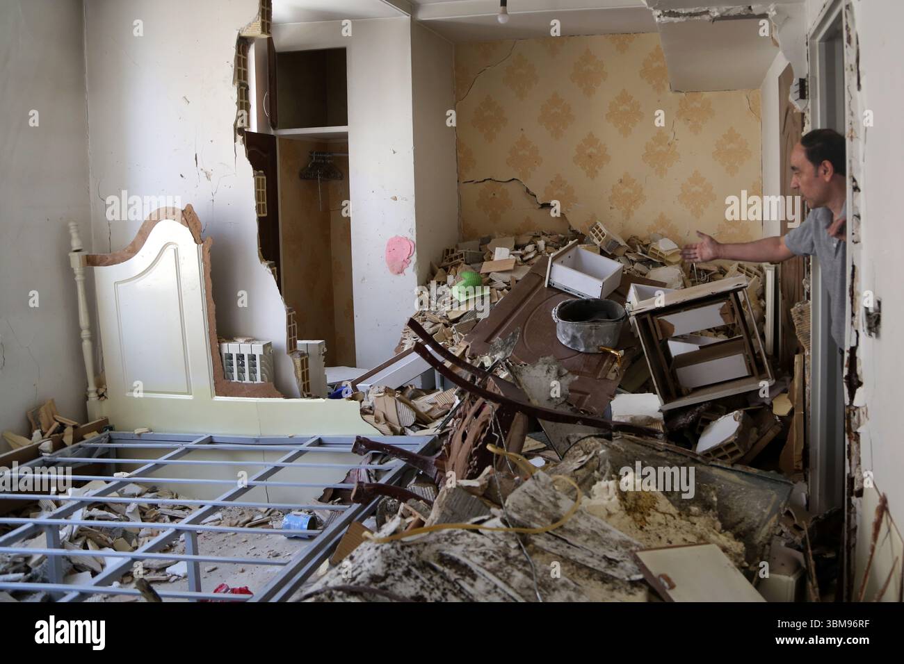 Tehran. 25th June, 2025. A man inspects inside a building damaged ...