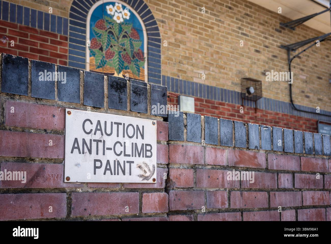 "Caution Anti-climb paint" sign on a wall surrounding residential ...
