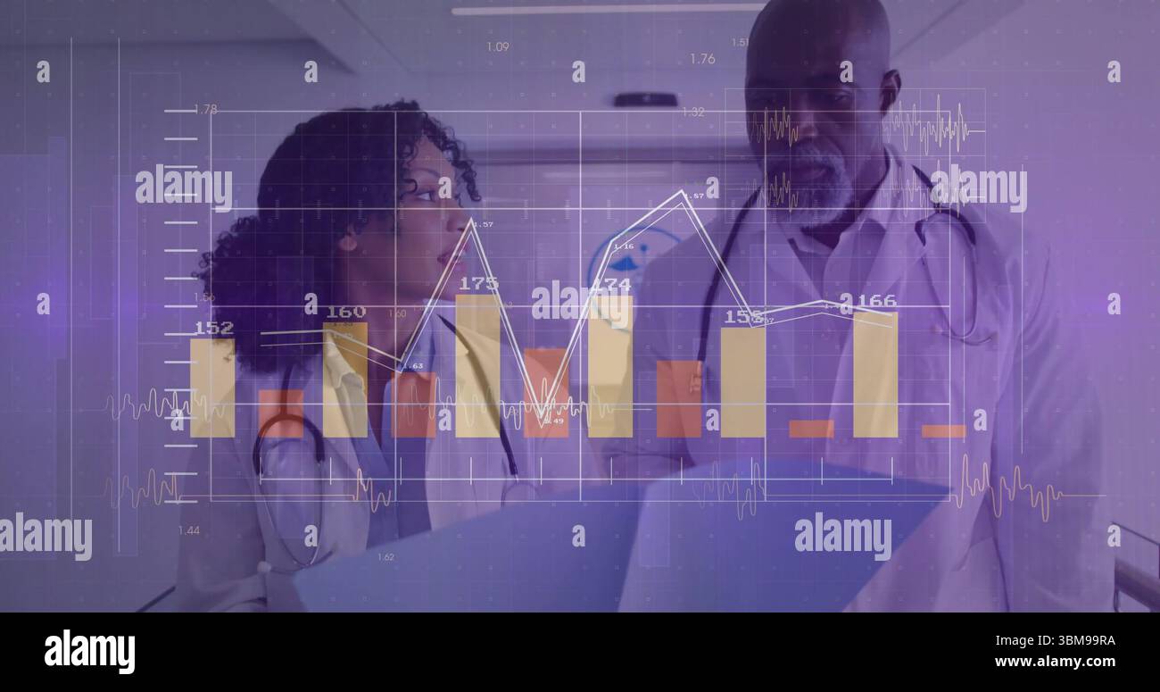Reviewing charts medical team in lab coats at hospital corridor, with ...