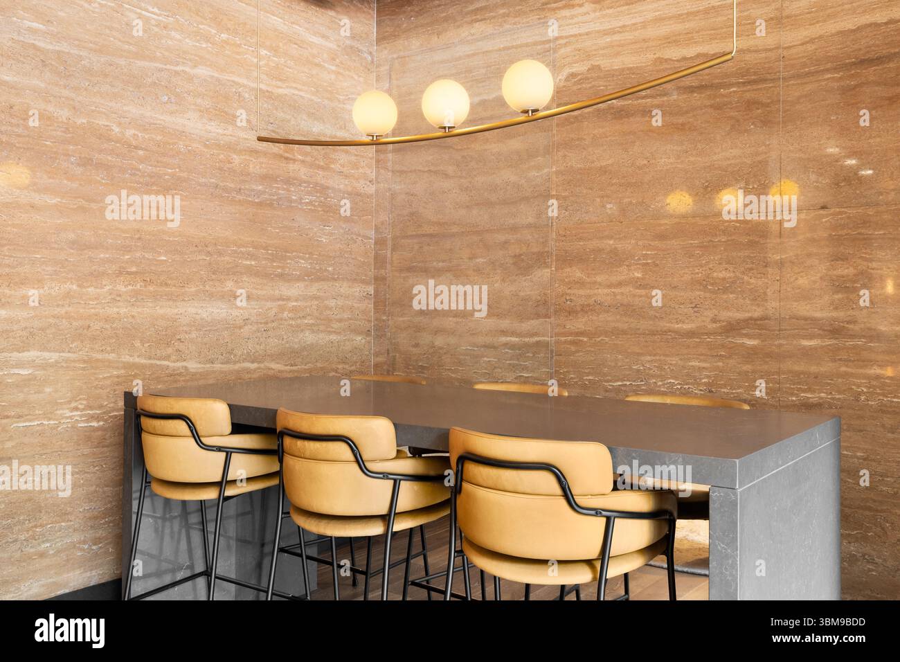 A luxury dining room detail with orange granite slab walls, a gold ...