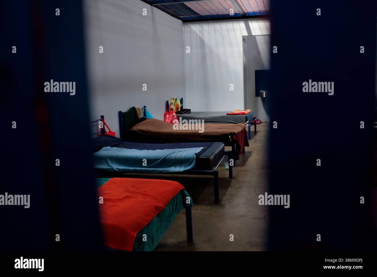 Photographed between bars, beds fill a cell at the Los Lagos detention ...