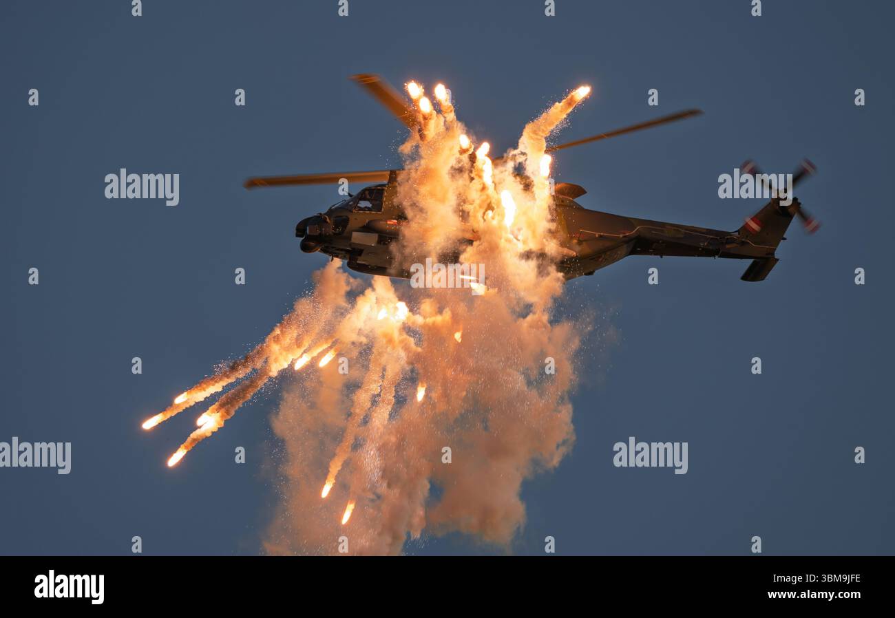 Modern military helicopter during a defensive maneuver,firing flares ...